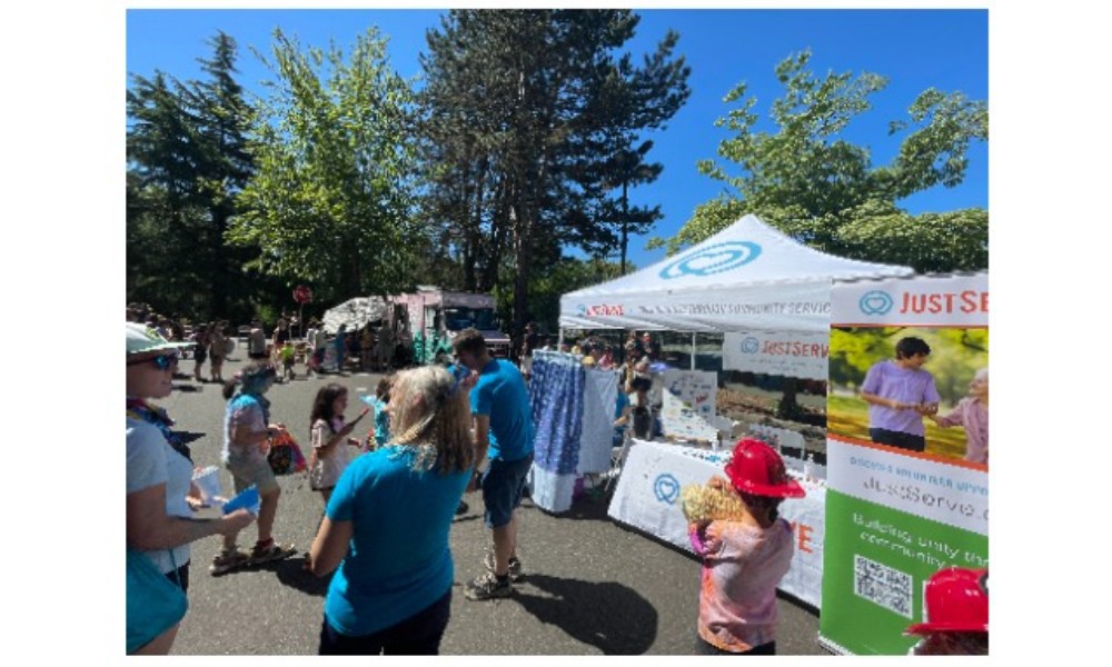 Volunteer booth shares JustServe.org with the Community - JustServe